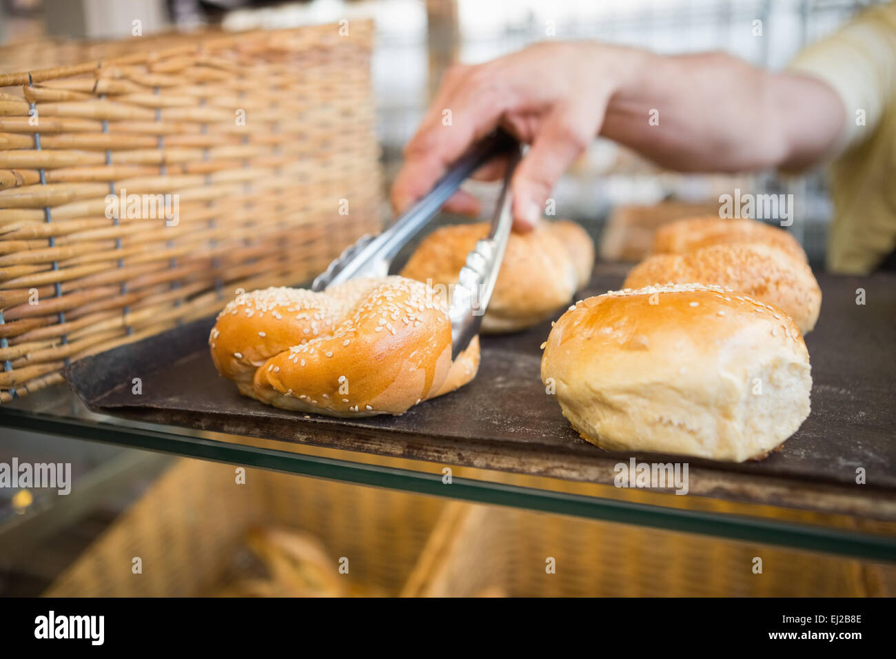 Hand of server taking bread with tongs Stock Photo - Alamy