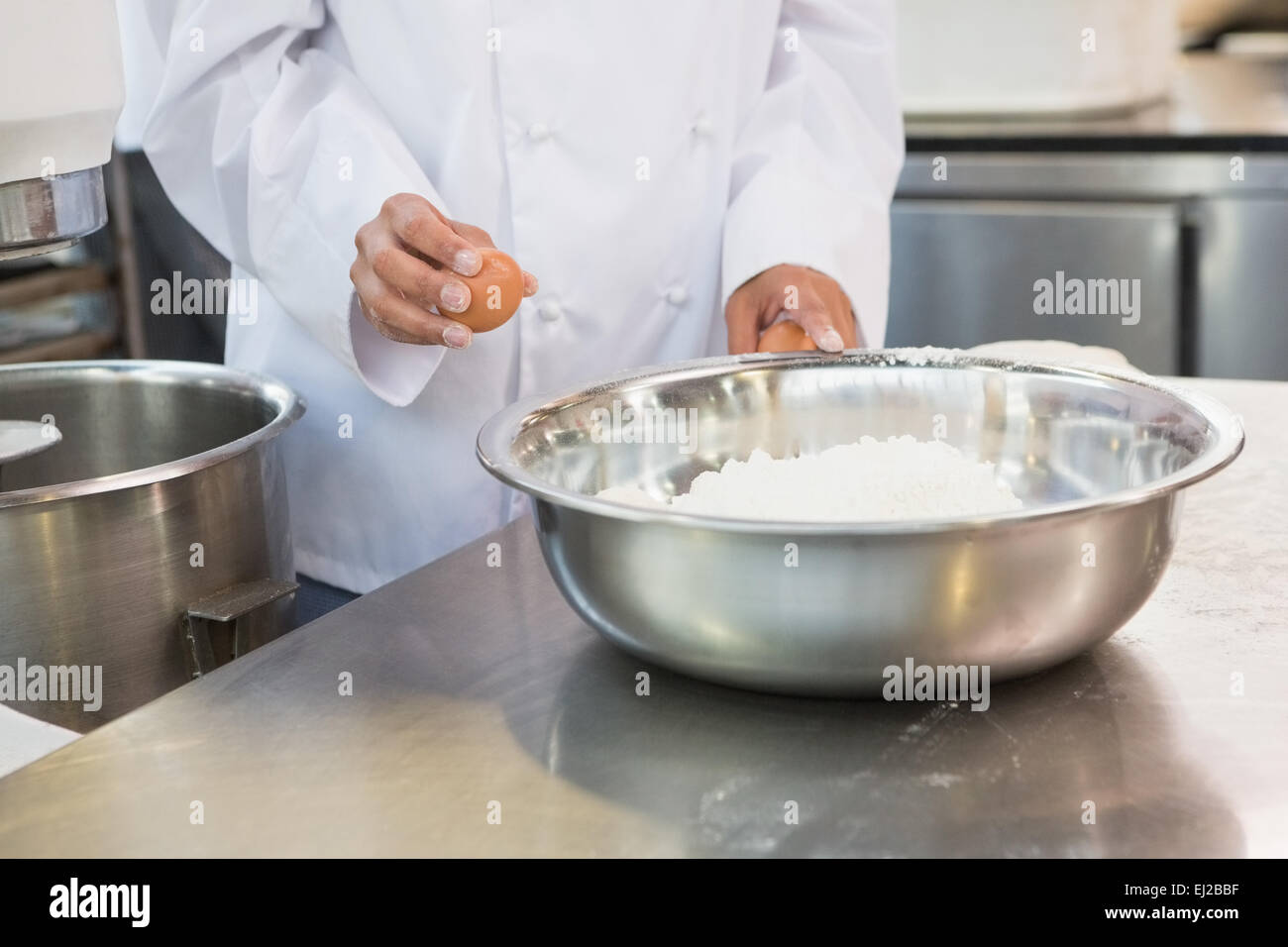 Baker making dough with eggs and flour Stock Photo - Alamy