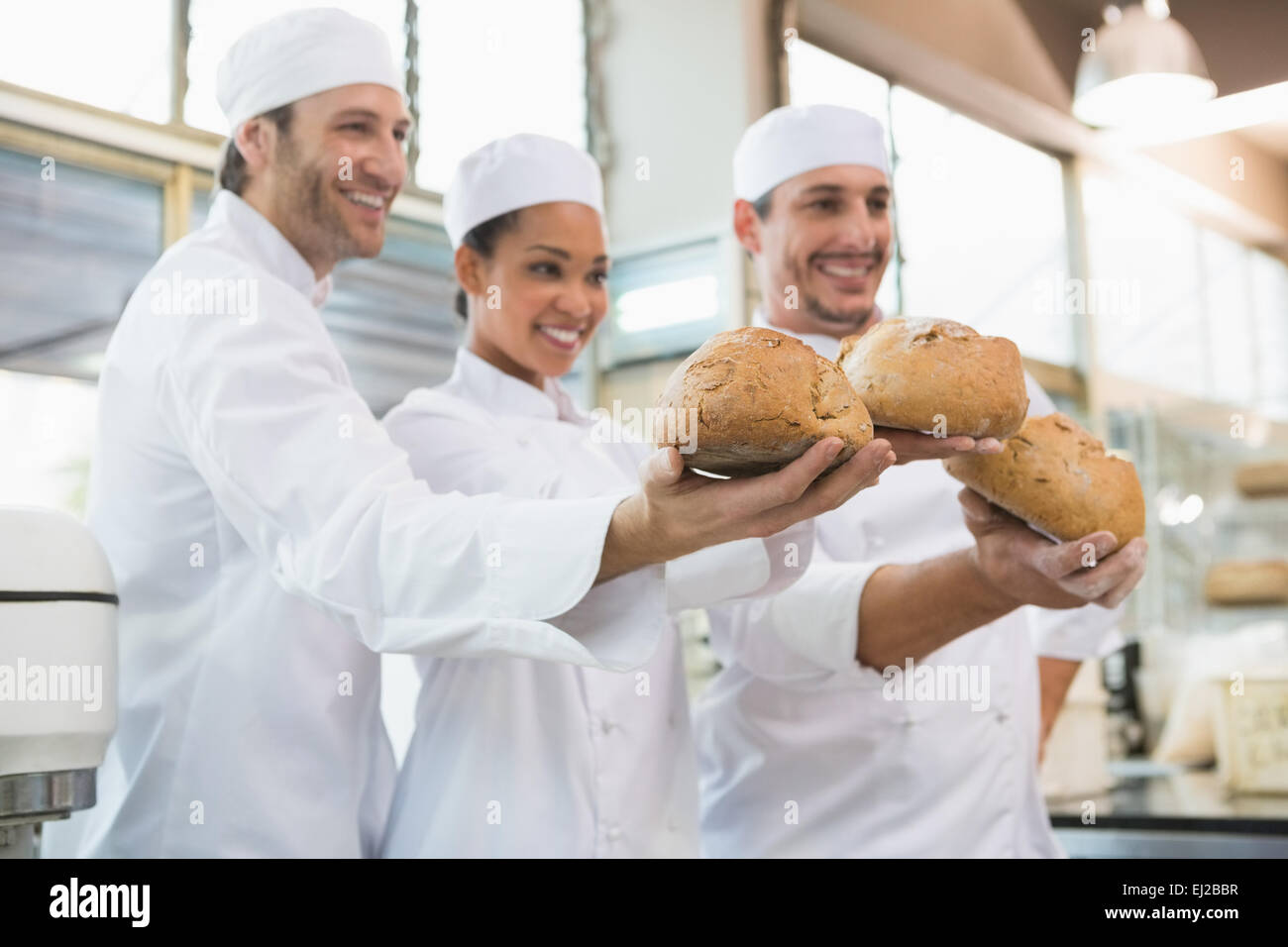 Smiling baker holding loaf bread hi-res stock photography and images ...