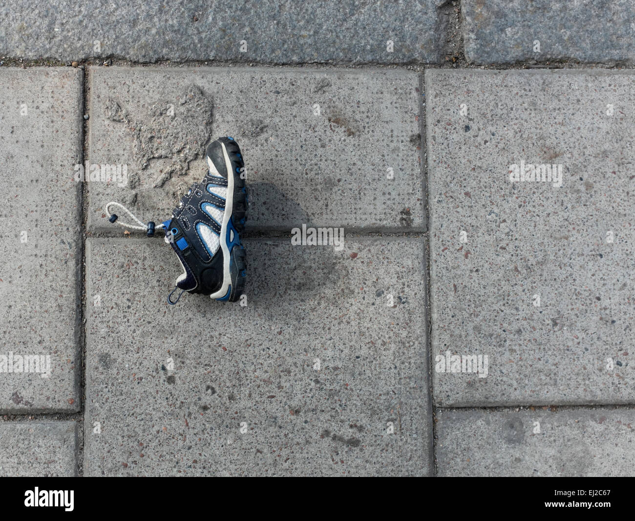 A lost children´s shoe on the pavement Stock Photo - Alamy