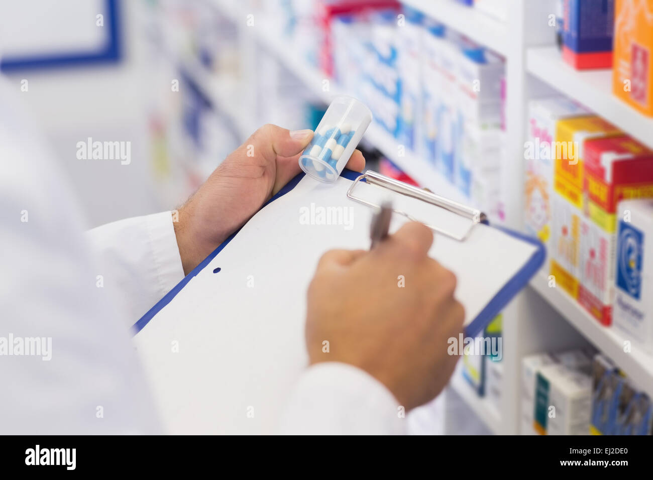 Pharmacist writing on clipboard Stock Photo - Alamy