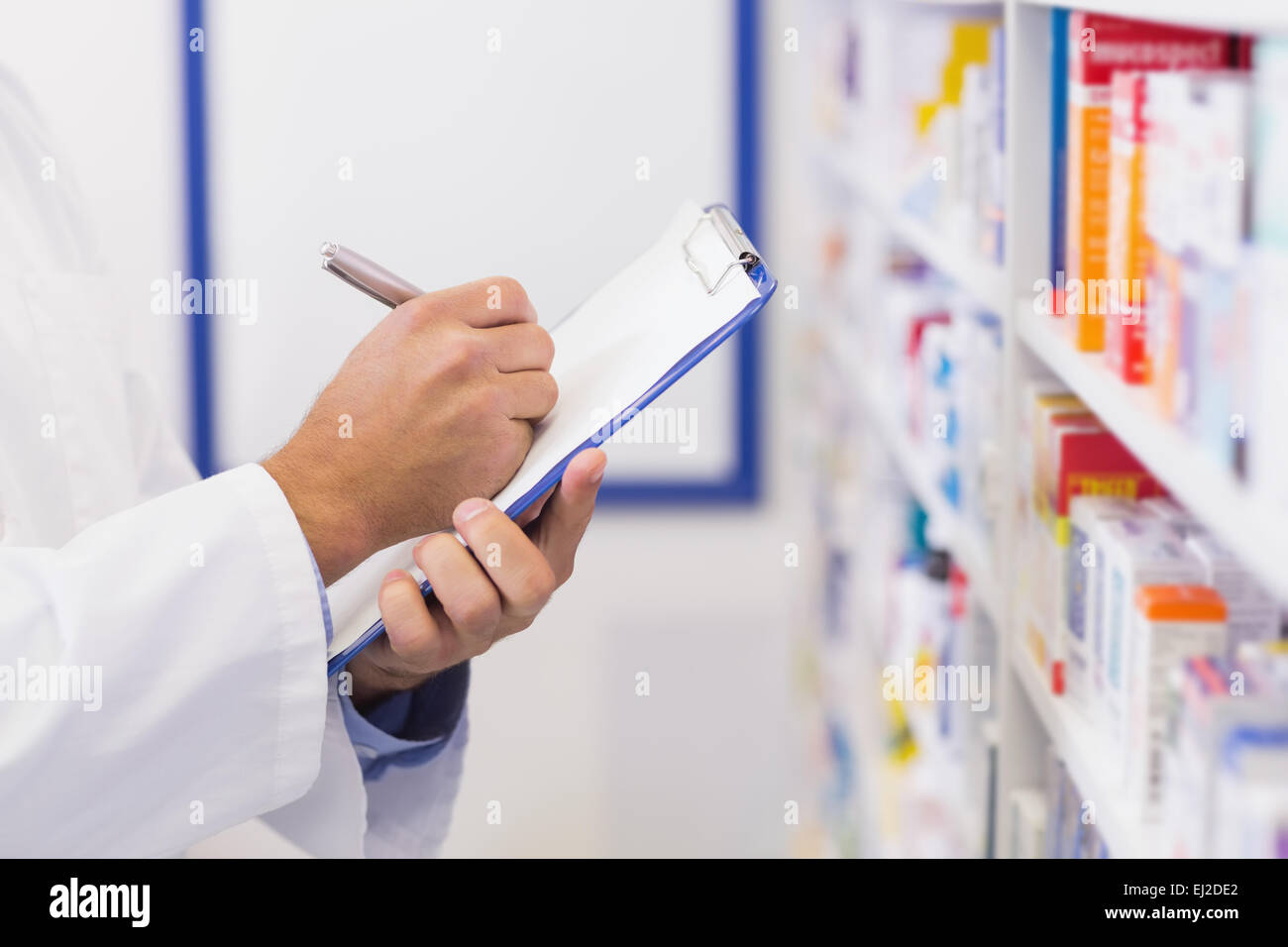 Pharmacist writing on clipboard Stock Photo - Alamy