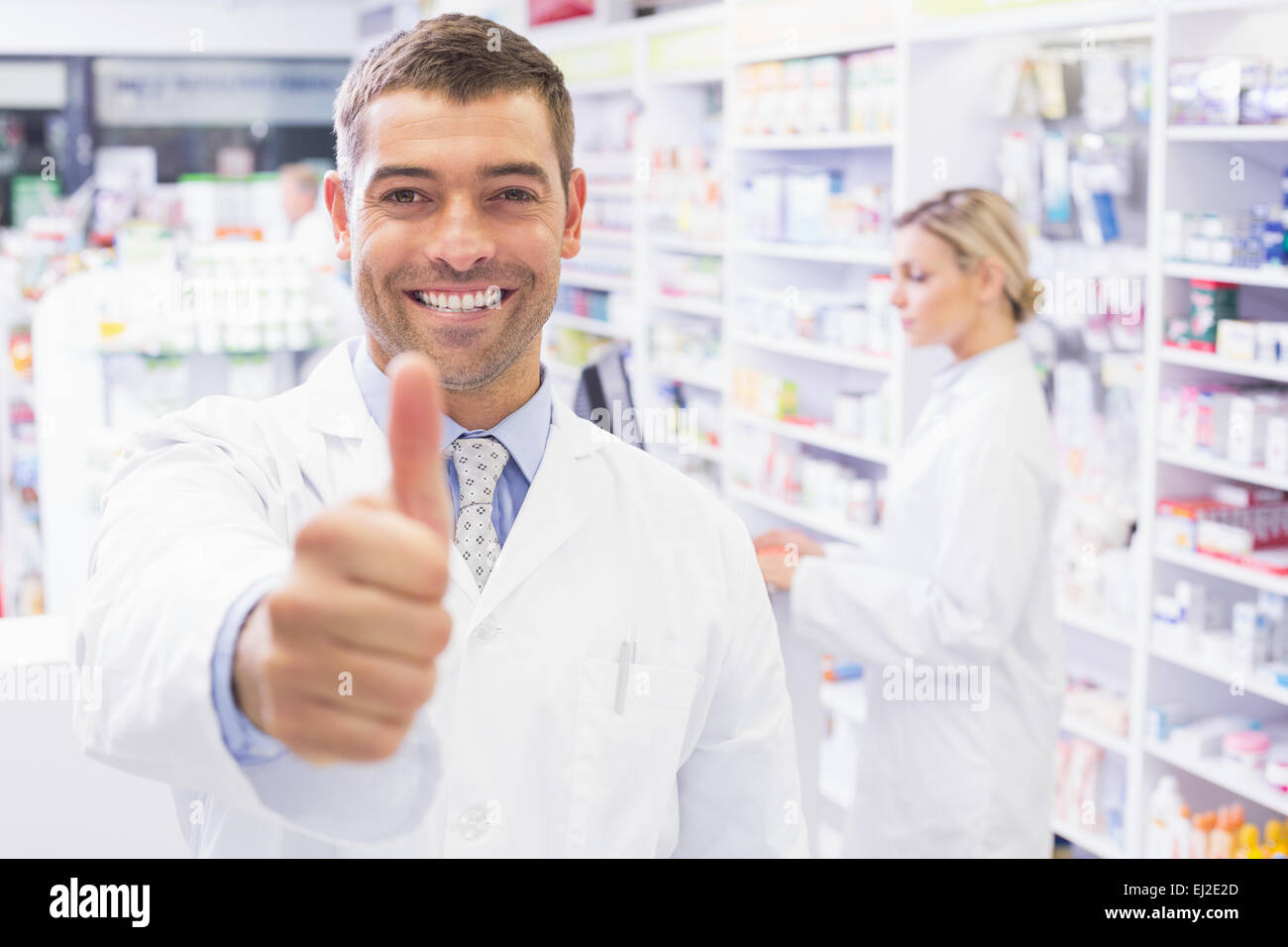 Happy pharmacist holding his thumb Stock Photo - Alamy