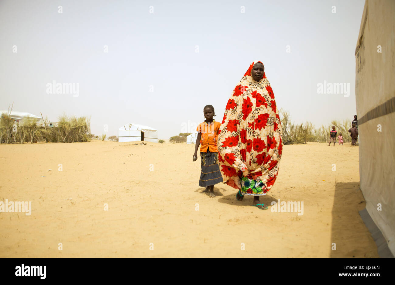 Eyande Ali (30, R) and her daughter Aisha (6) walk in a refugee camp in ...