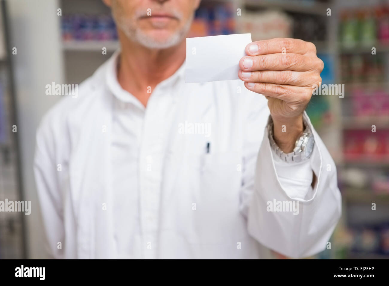 Senior pharmacist holding calling card Stock Photo - Alamy