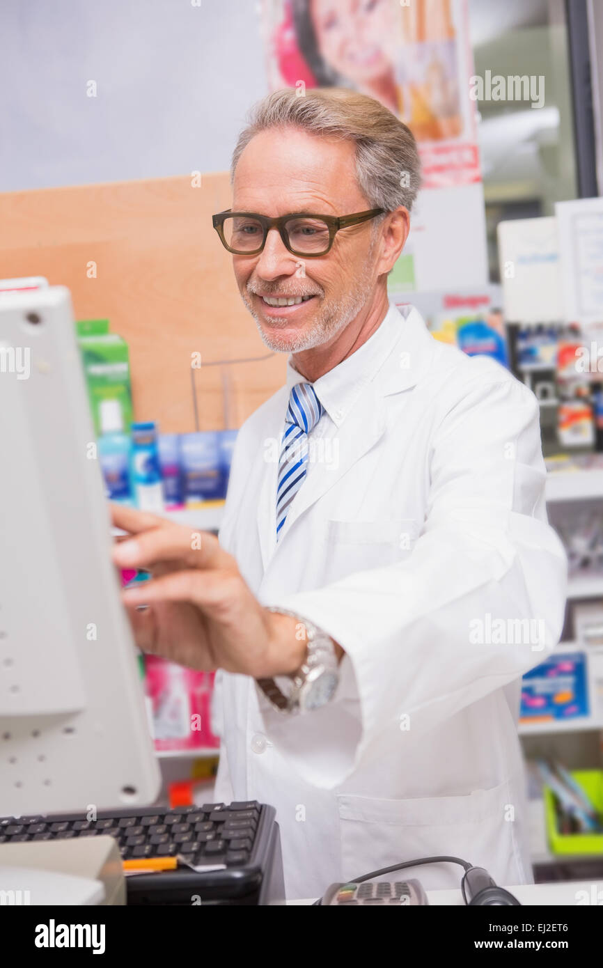 Smiling pharmacist using the computer Stock Photo - Alamy