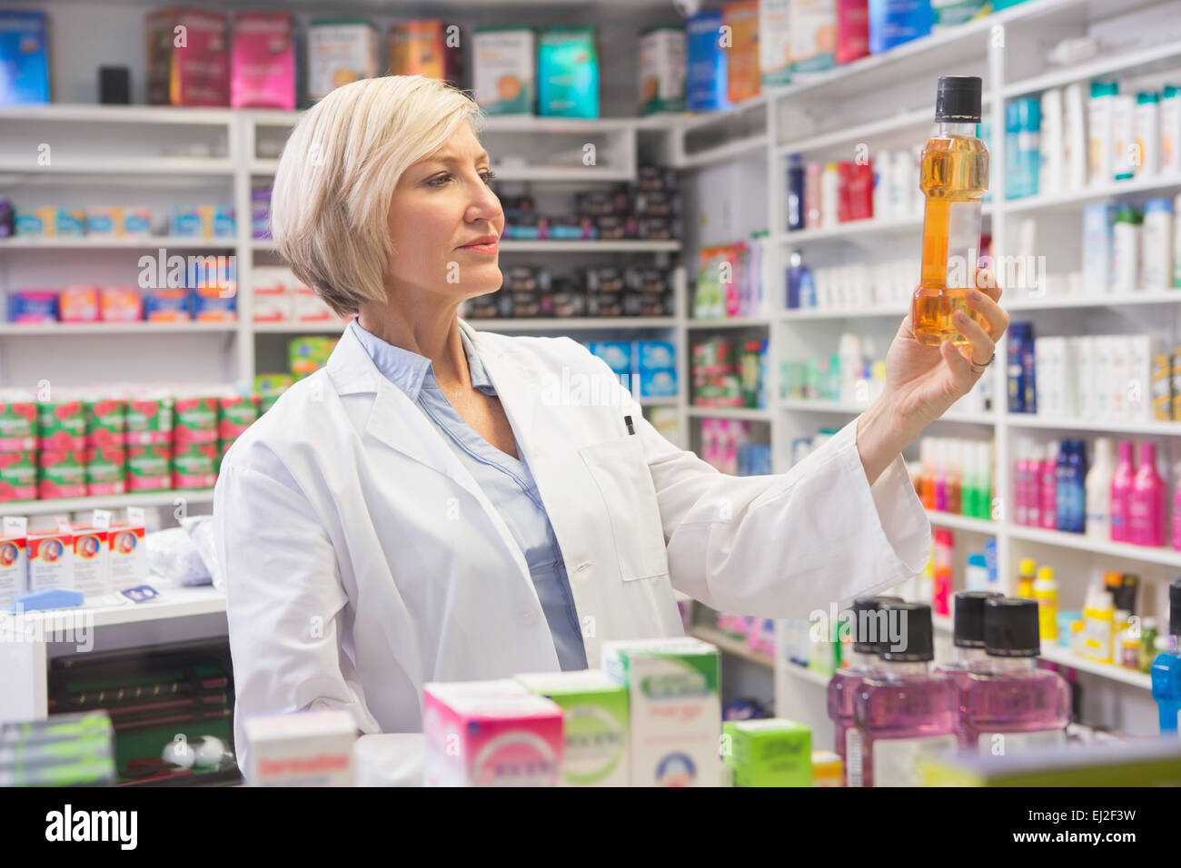 Cheerful pharmacist holding medication Stock Photo - Alamy