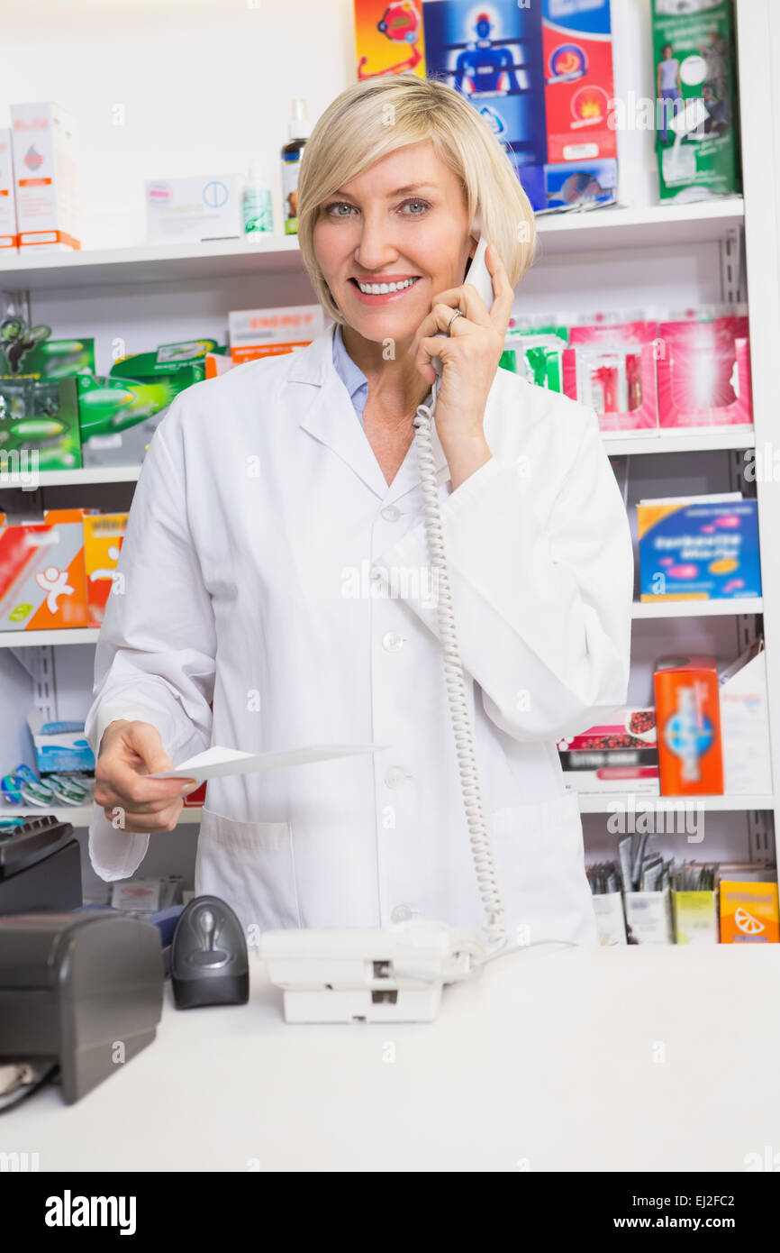 Smiling pharmacist on the phone reading prescription Stock Photo - Alamy