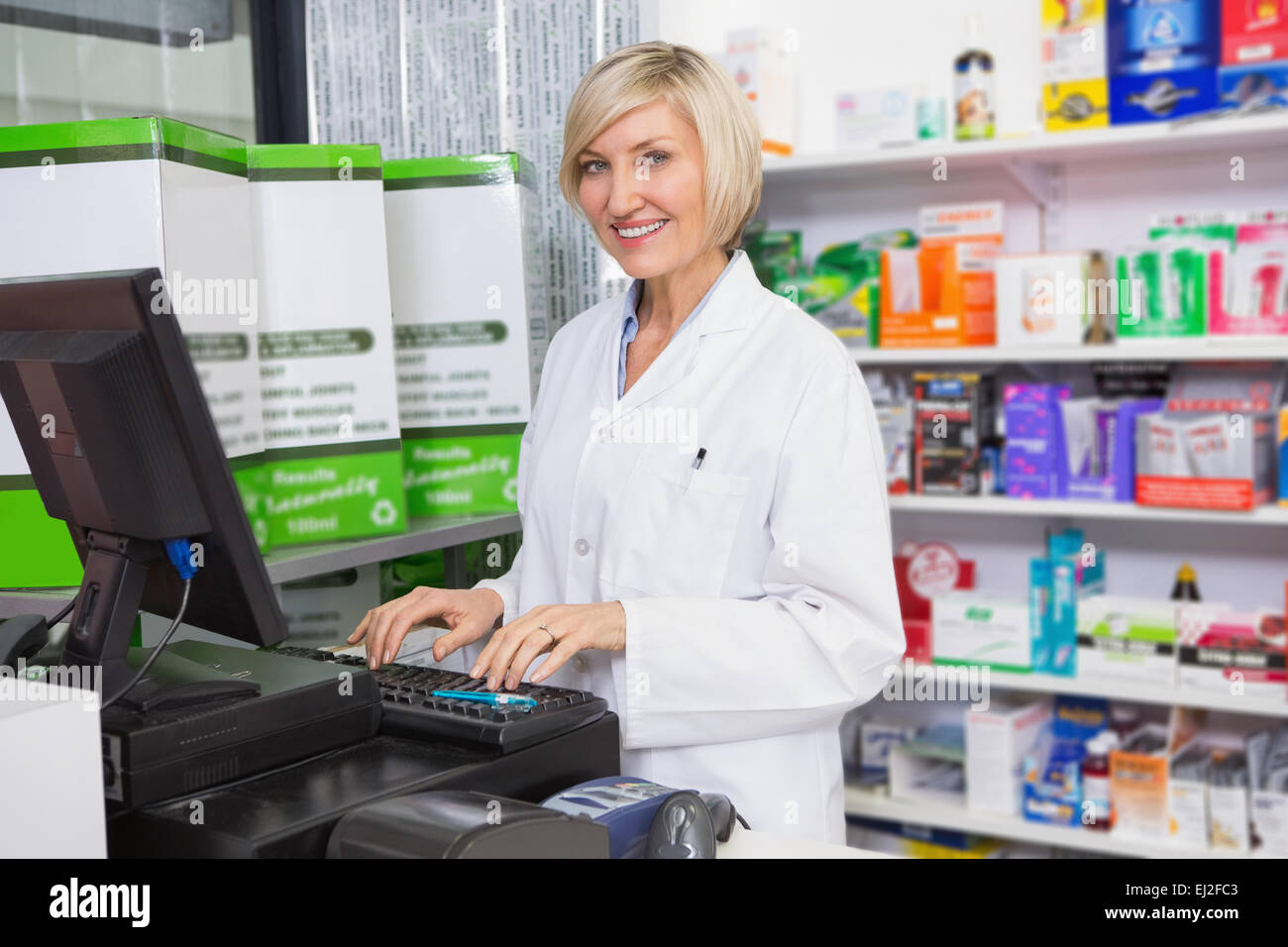 Smiling pharmacist using computer Stock Photo - Alamy