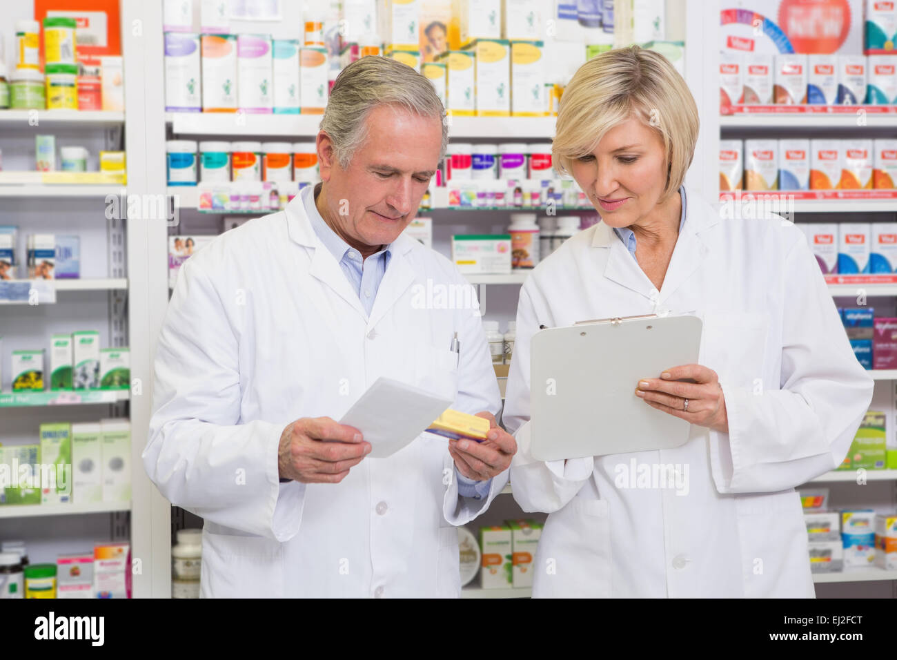Smiling pharmacists team talking about medication Stock Photo - Alamy
