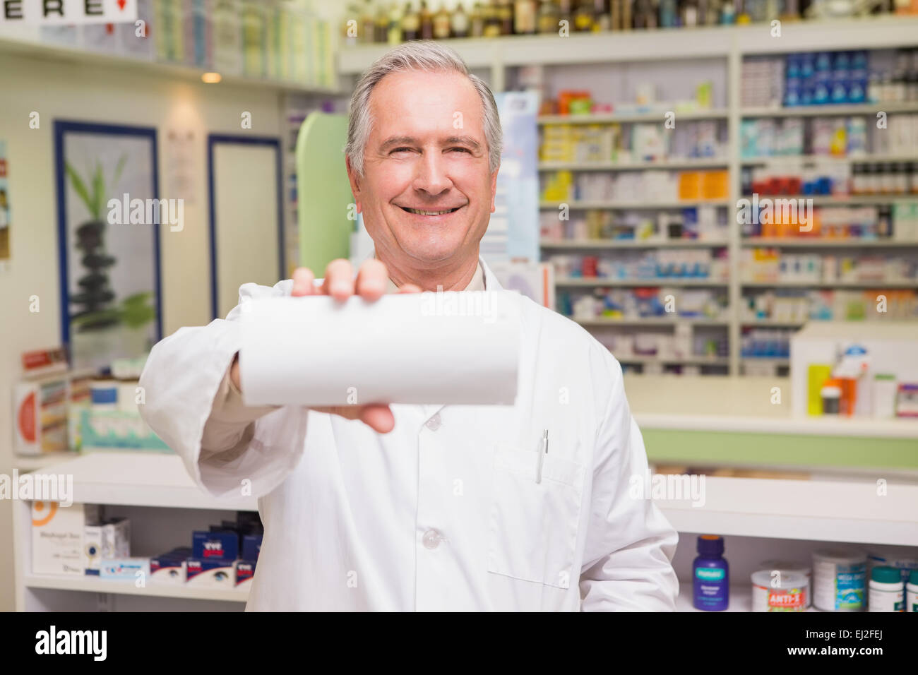 Smiling senior pharmacist showing paper Stock Photo - Alamy