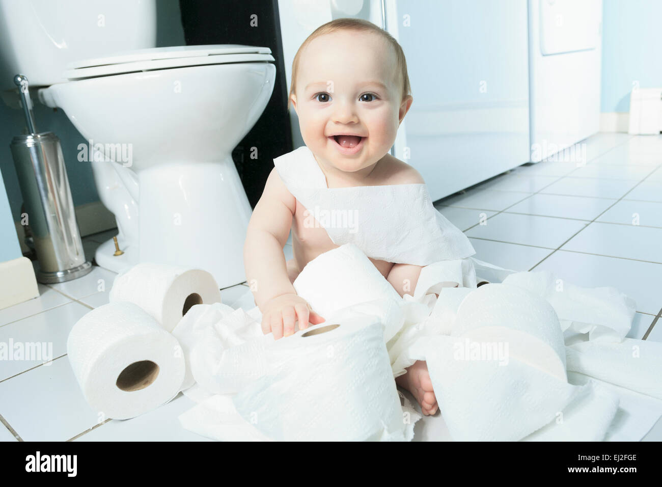 Toddler ripping up toilet paper in bathroom Stock Photo - Alamy