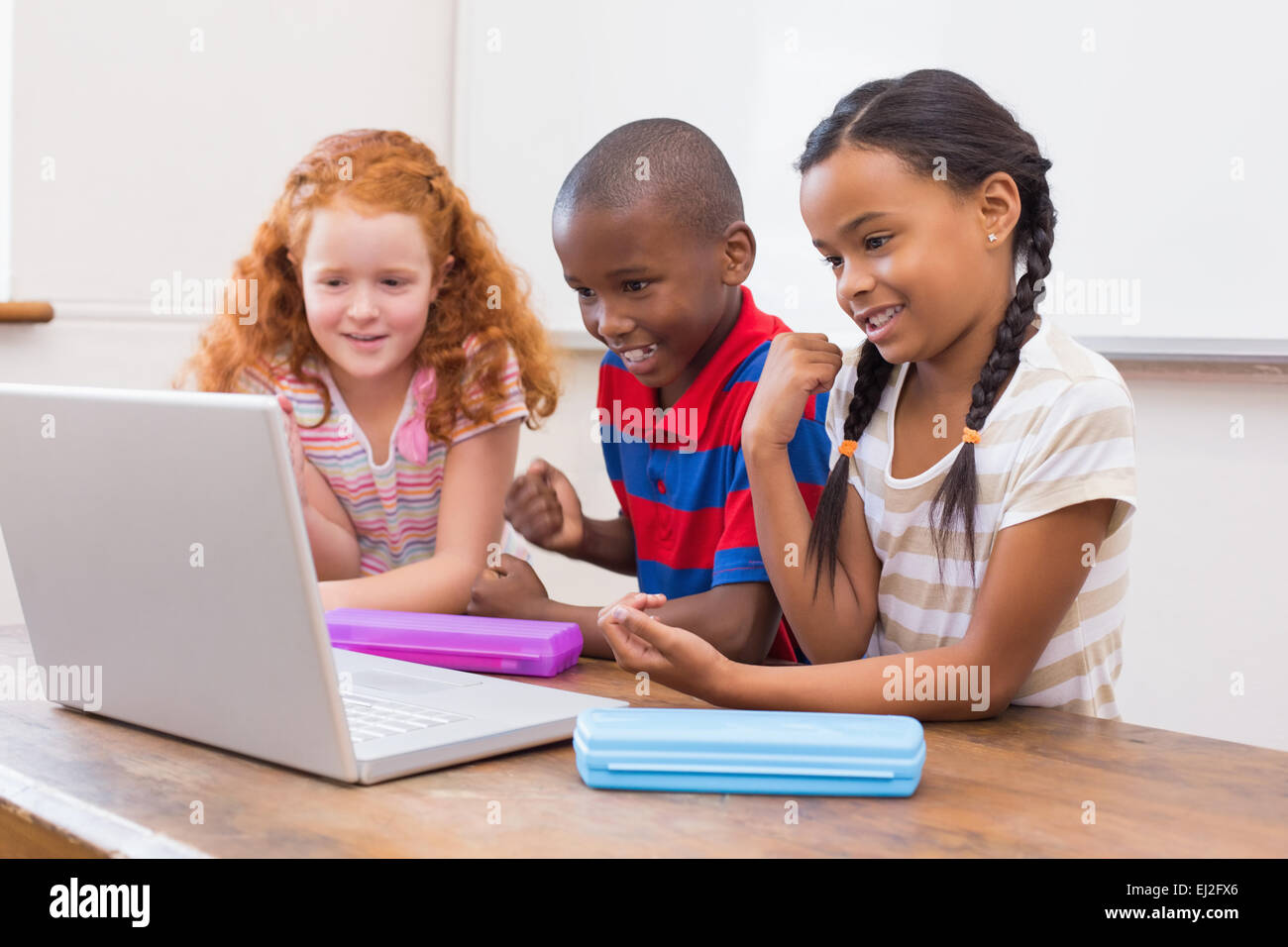 Cute pupils using computer Stock Photo - Alamy