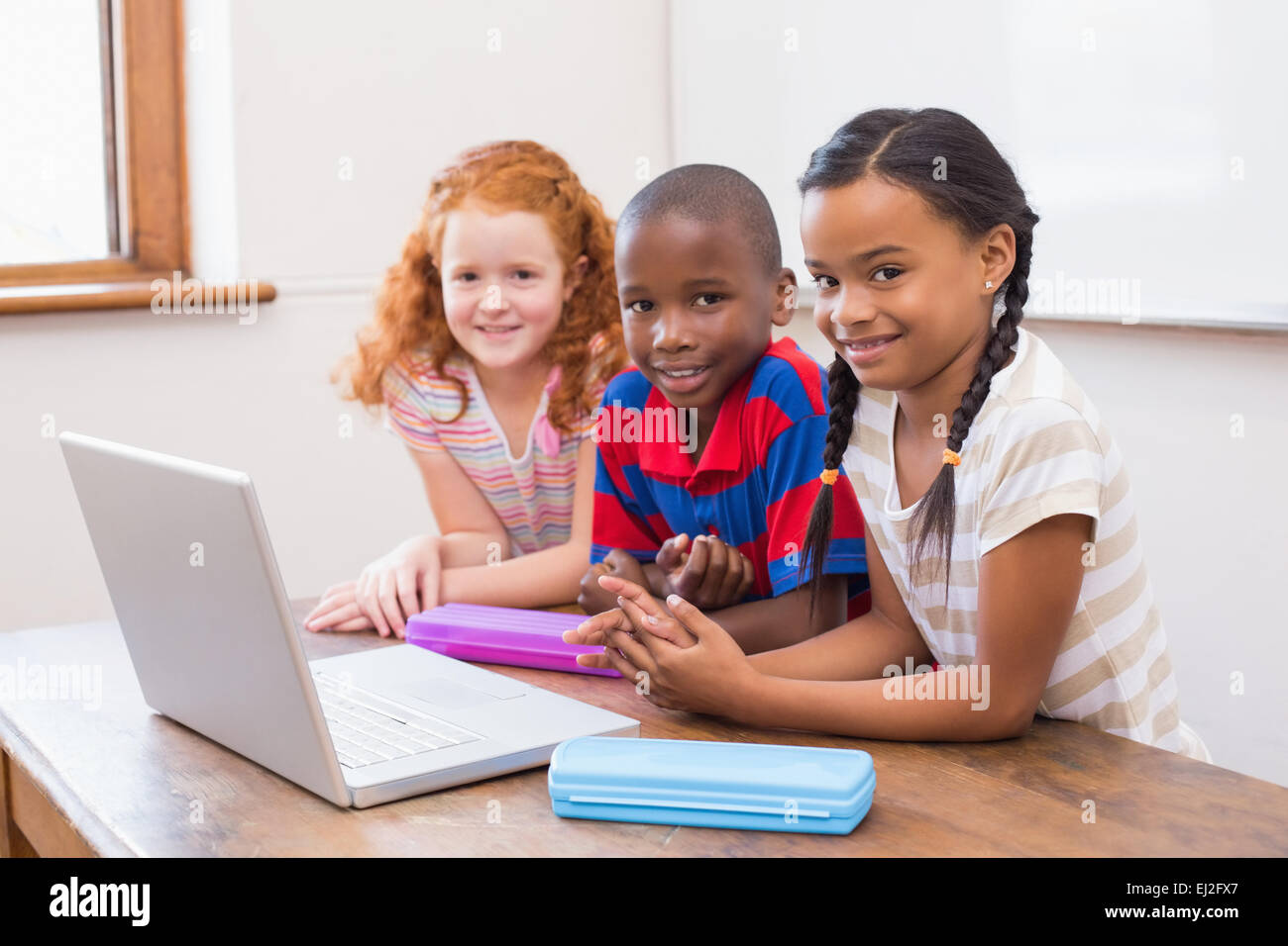 Cute pupils using computer Stock Photo - Alamy