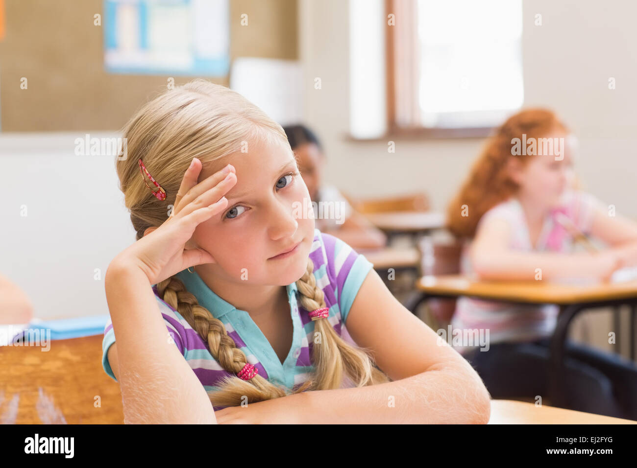 Thoughtful pupil sitting at his desk Stock Photo - Alamy