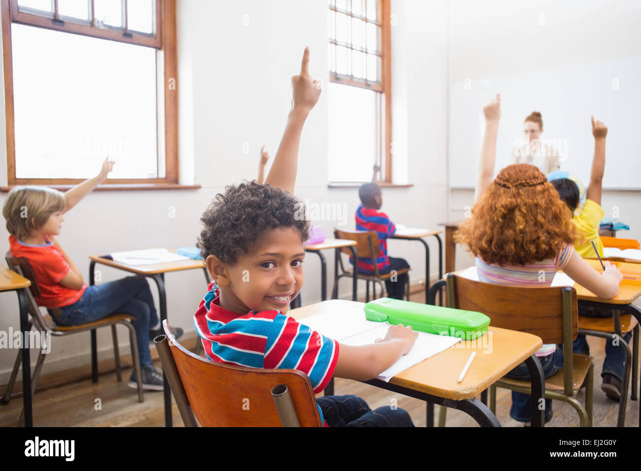 Pupil raising their hands during class Stock Photo - Alamy