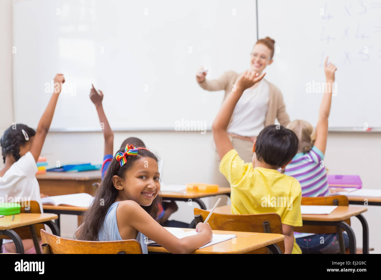 Pupils raising hand in classroom Stock Photo - Alamy