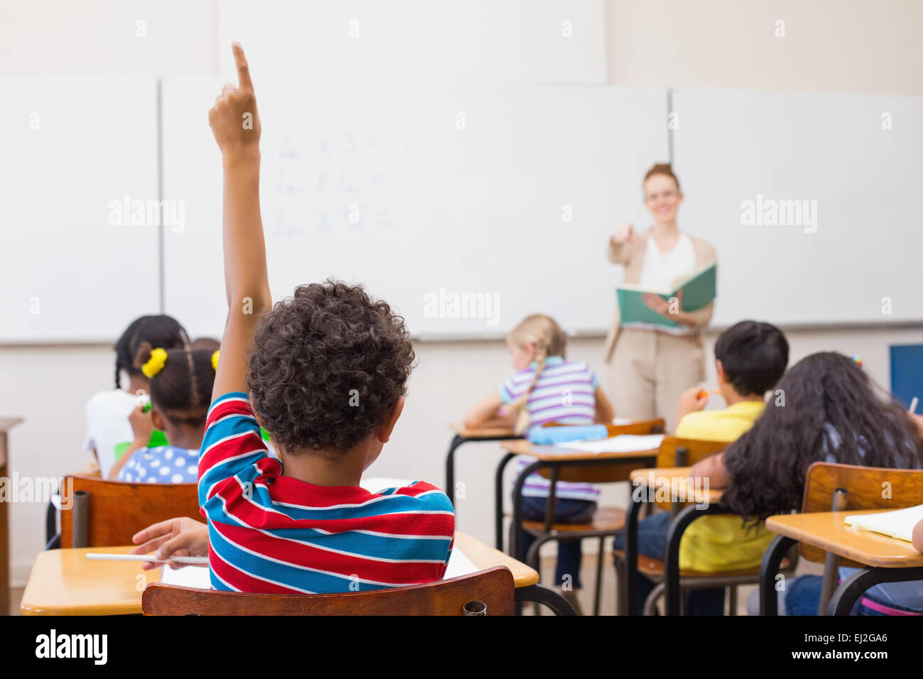 Pupils raising hand in classroom Stock Photo - Alamy