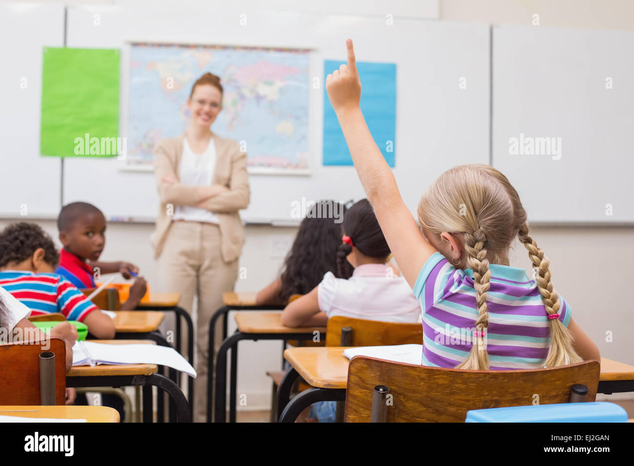 Pupil raising hand during geography lesson in classroom Stock Photo - Alamy