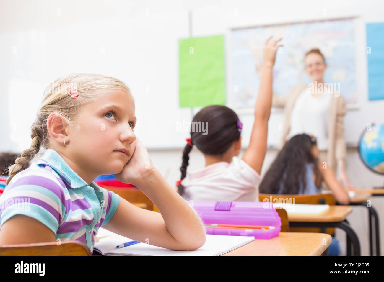 Thoughtful pupil sitting at her desk Stock Photo - Alamy