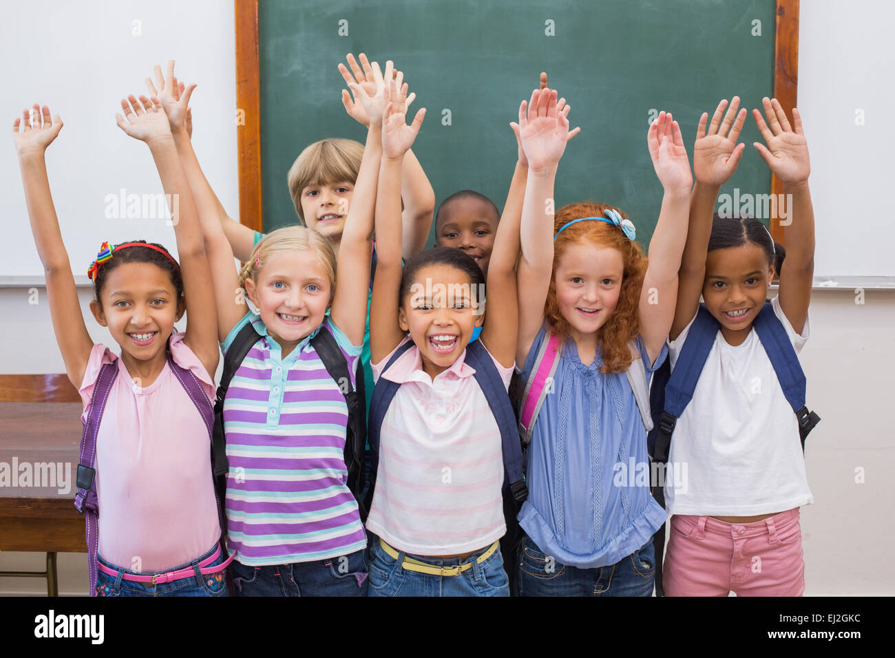 Cute pupils smiling at camera in classroom Stock Photo - Alamy