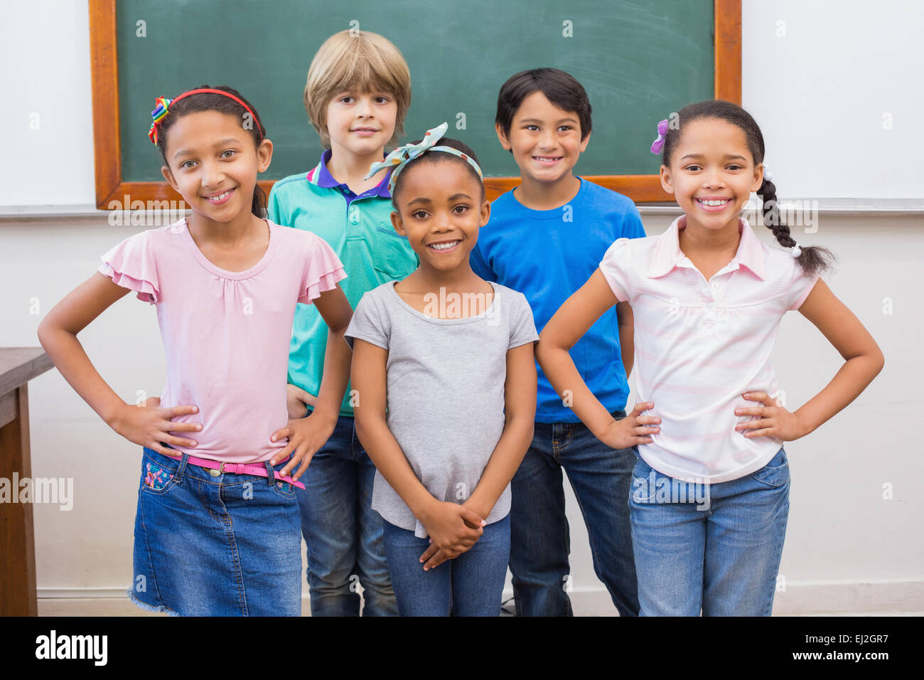 Cute pupils smiling at camera in classroom Stock Photo - Alamy