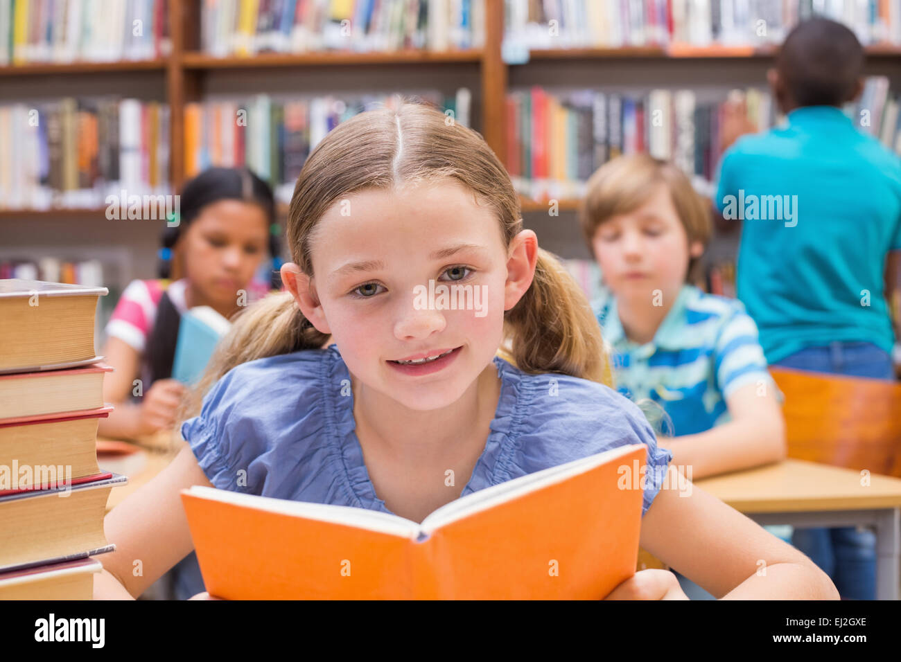 Cute pupils reading in library Stock Photo - Alamy