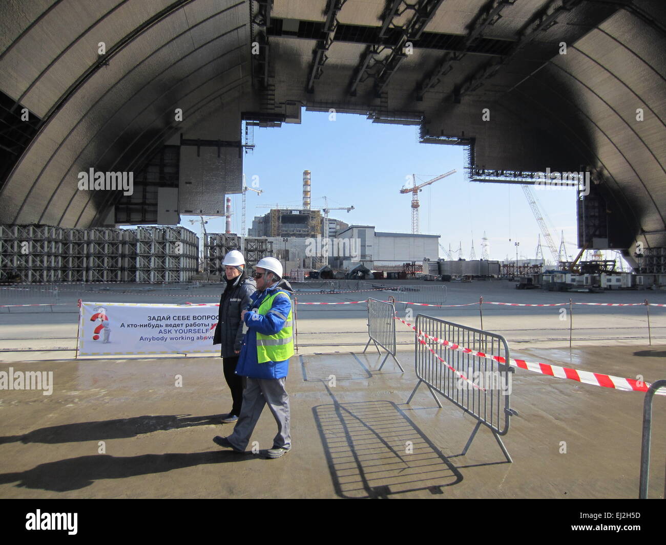 Workers walk under the new protective covering for the Chernobyl ...