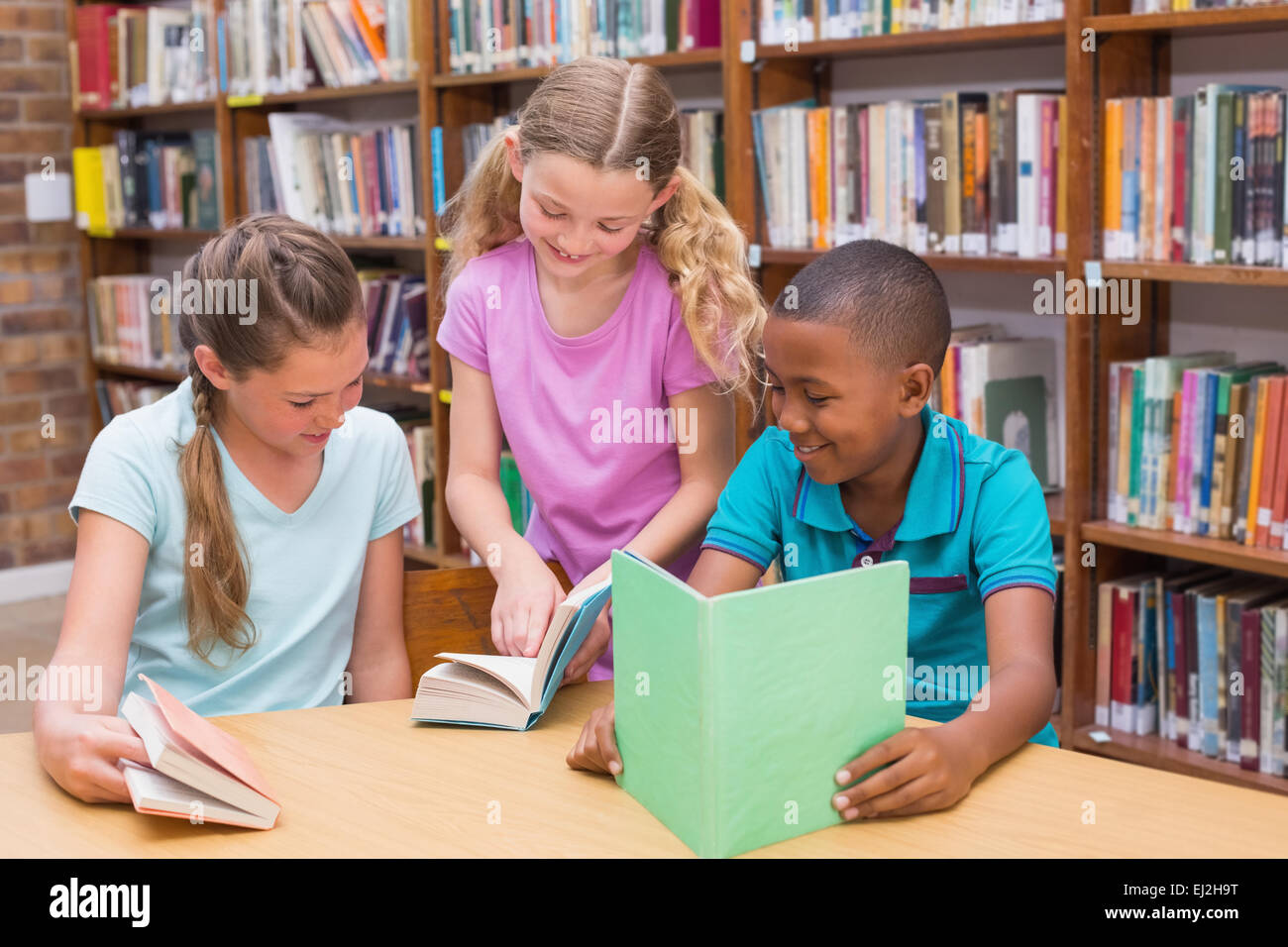 Cute pupils reading in library Stock Photo - Alamy