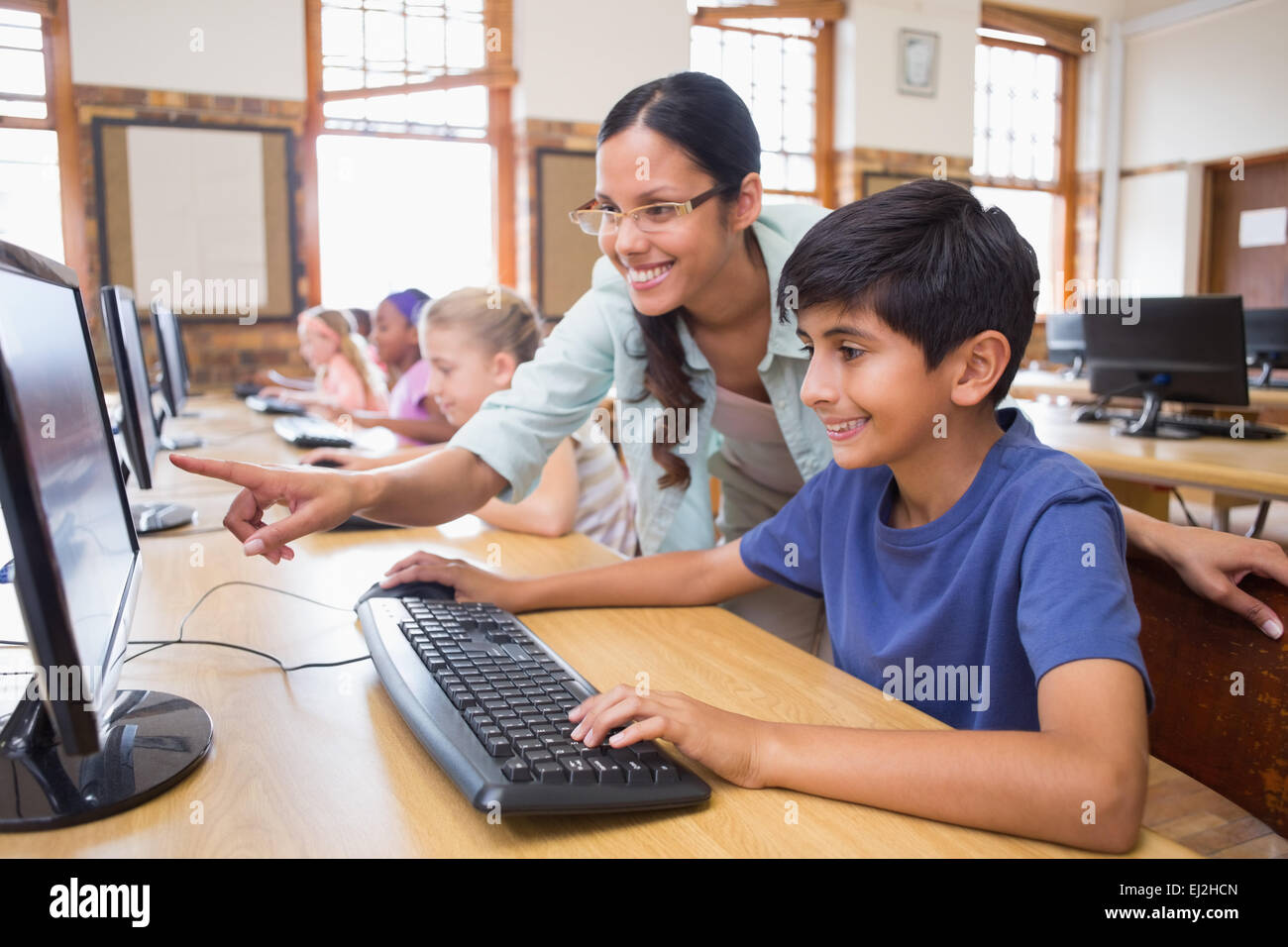 Cute pupils in computer class with teacher Stock Photo - Alamy