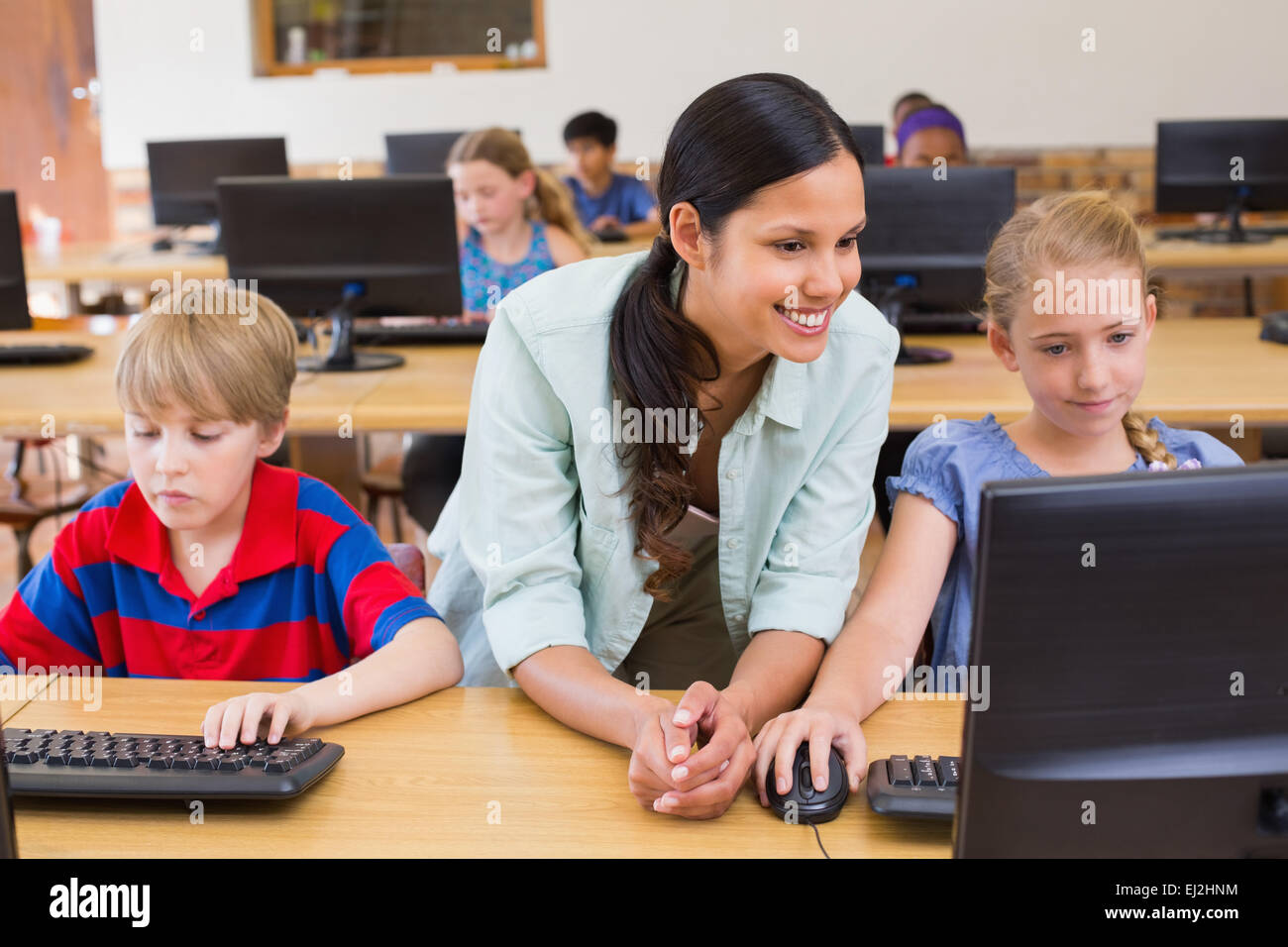 Cute pupils in computer class with teacher Stock Photo - Alamy