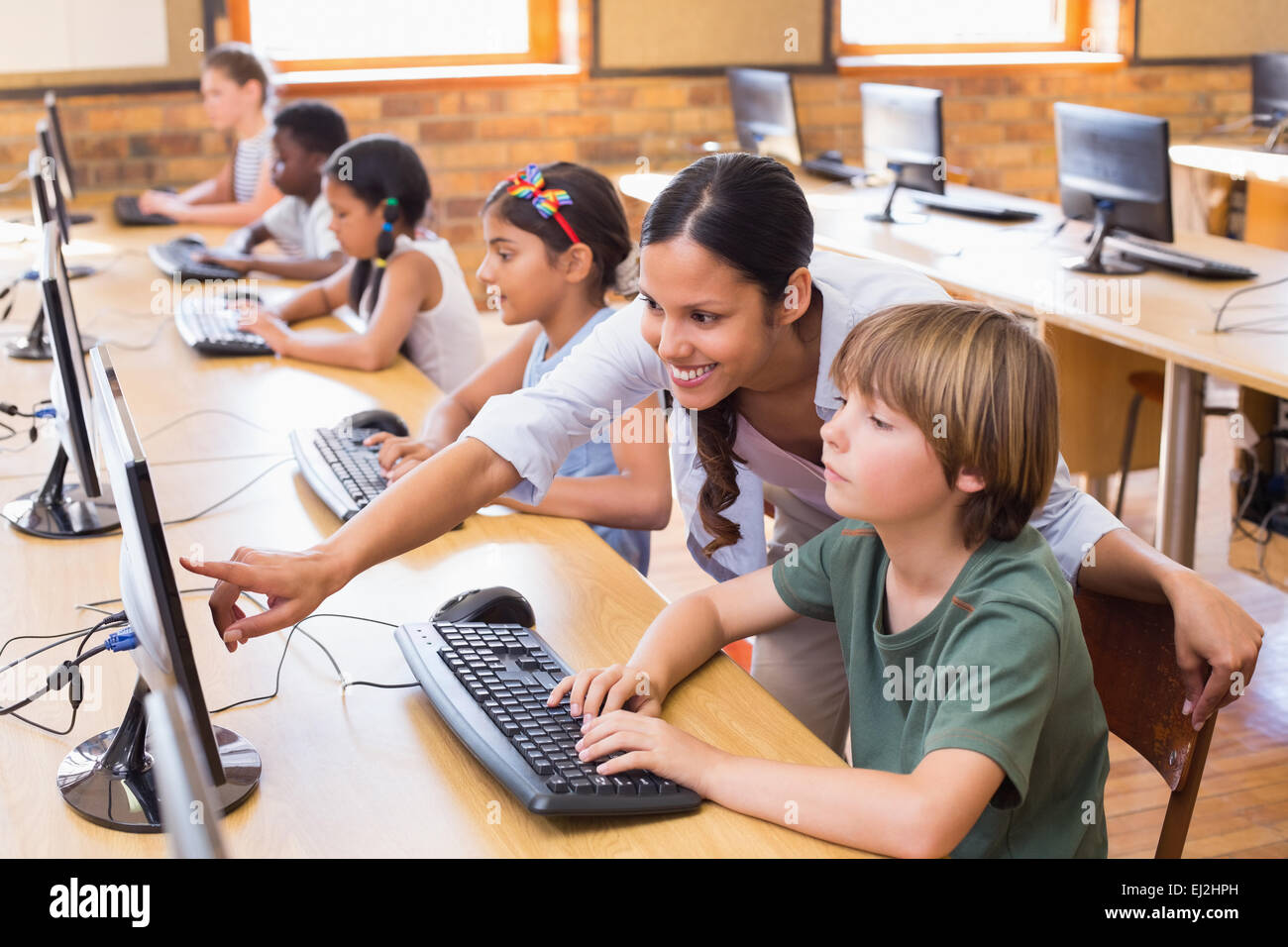 Cute pupils in computer class with teacher Stock Photo - Alamy