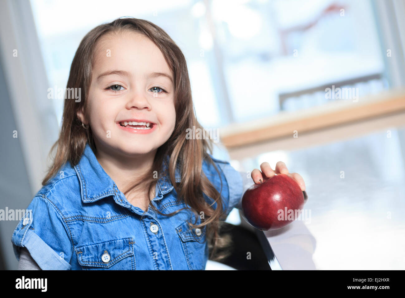 A children girl at kitchen with apple Stock Photo - Alamy