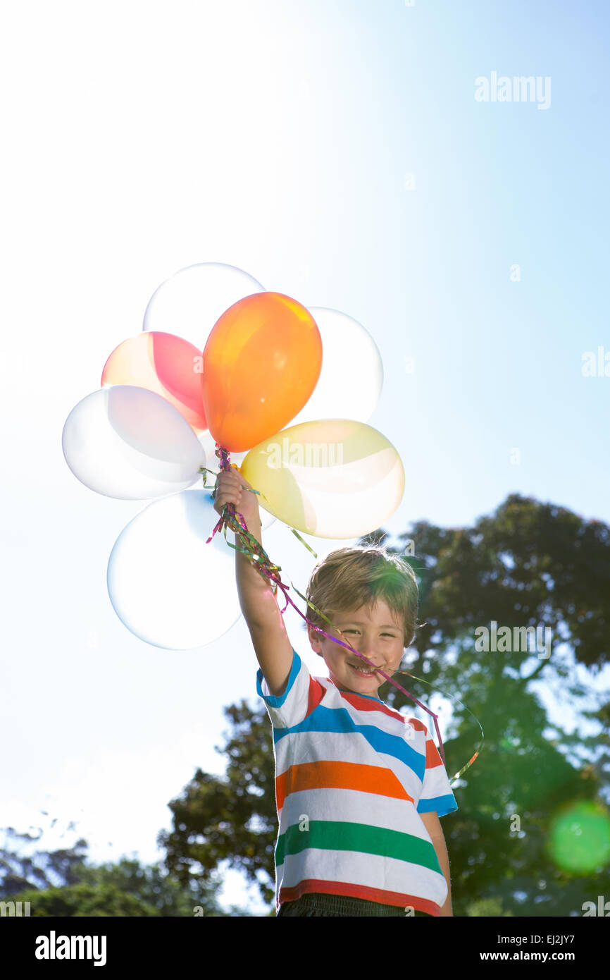 Happy little boy holding balloons Stock Photo - Alamy