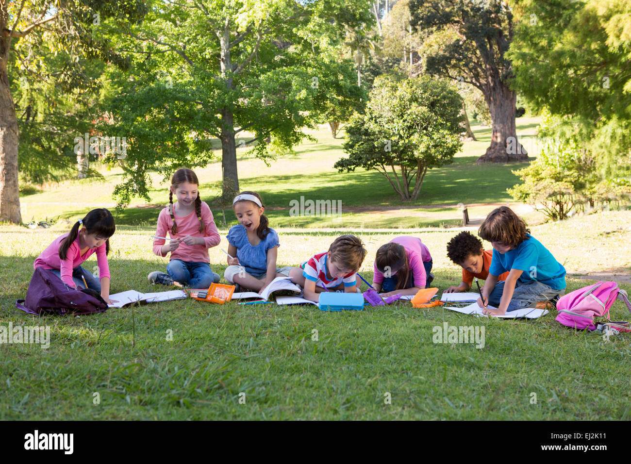 School children doing homework on grass Stock Photo - Alamy