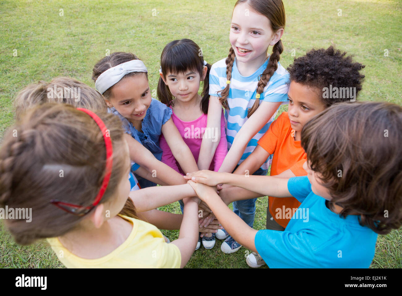 Little children putting hands together Stock Photo - Alamy