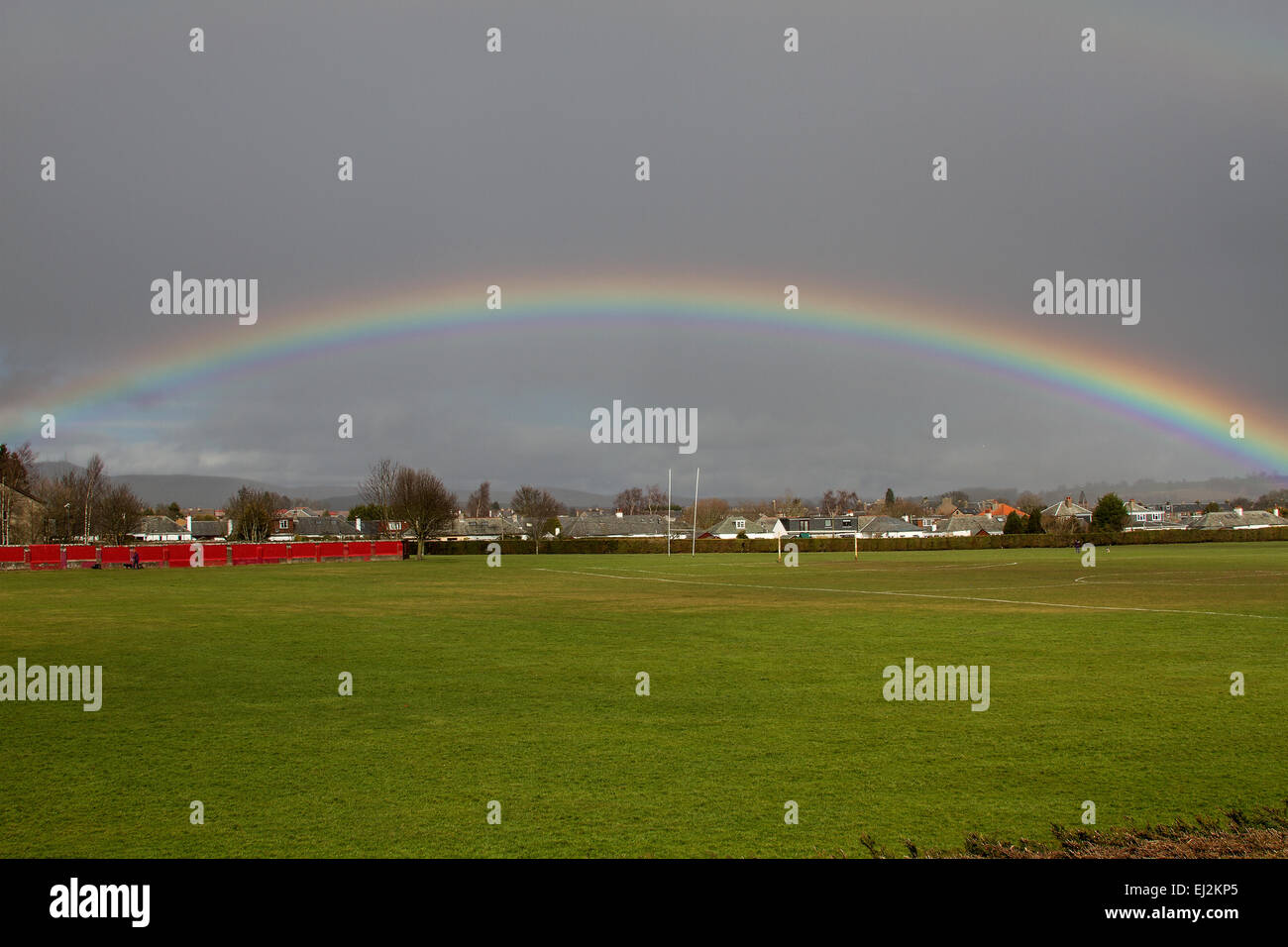 Colourful rainbow stretching across a playing field after a freak rain ...