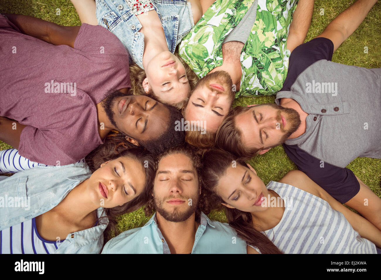 Happy young friends lying on grass Stock Photo - Alamy