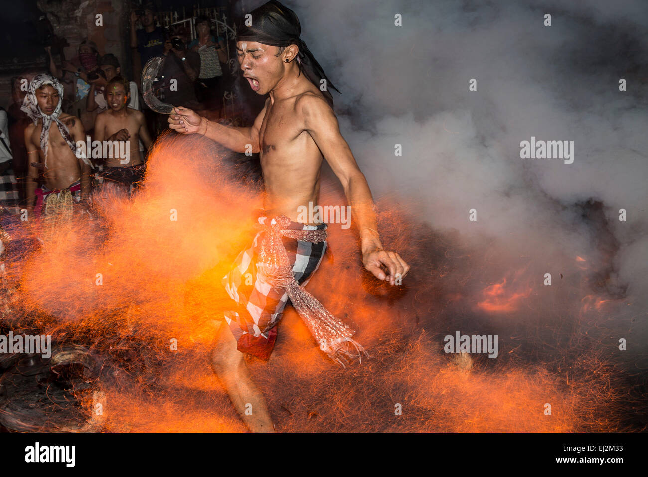 Ubud, Bali, Indonesia, March 20, 2015. Participant kicks up the fire ...