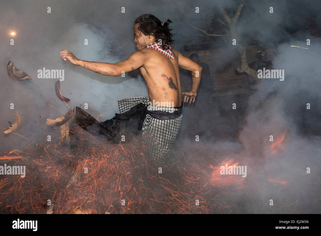 Ubud, Bali, Indonesia, March 20, 2015. Participant kicks up the fire ...