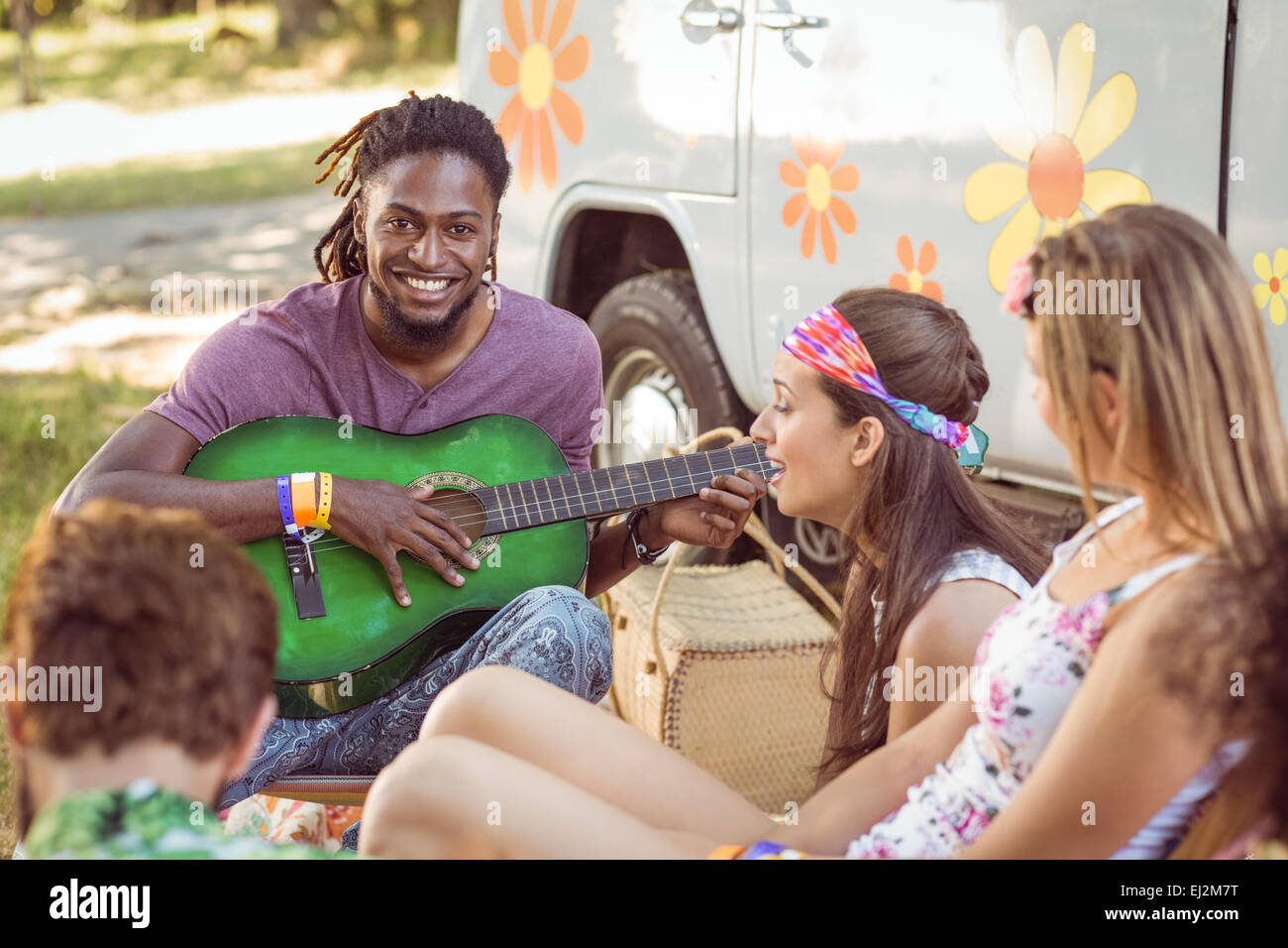 Happy hipster smiling at camera playing guitar Stock Photo - Alamy
