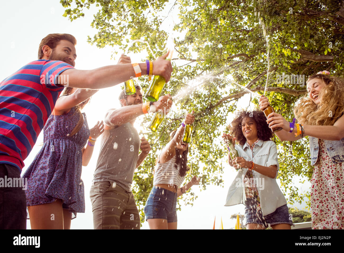 Happy hipsters spraying beer bottles Stock Photo - Alamy