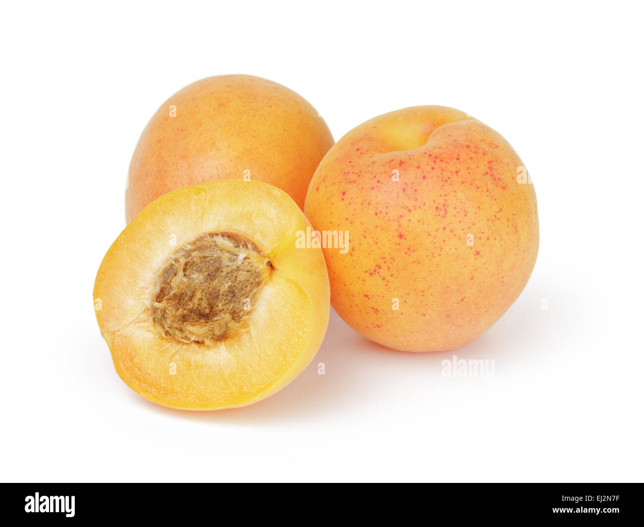 three ripe apricot fruits one half sliced isolated Stock Photo - Alamy