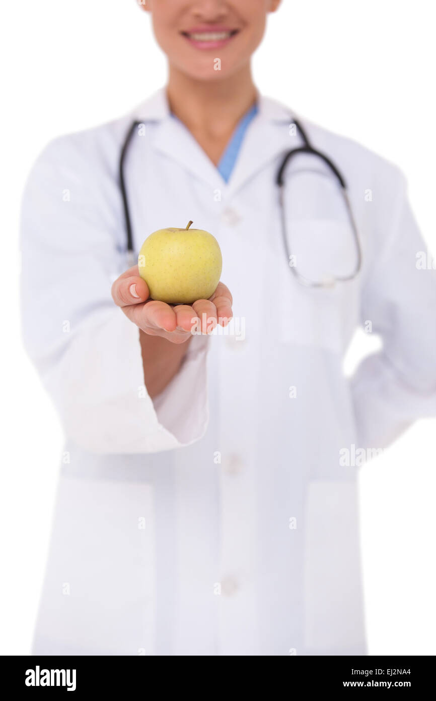 Smiling doctor offering an apple Stock Photo - Alamy