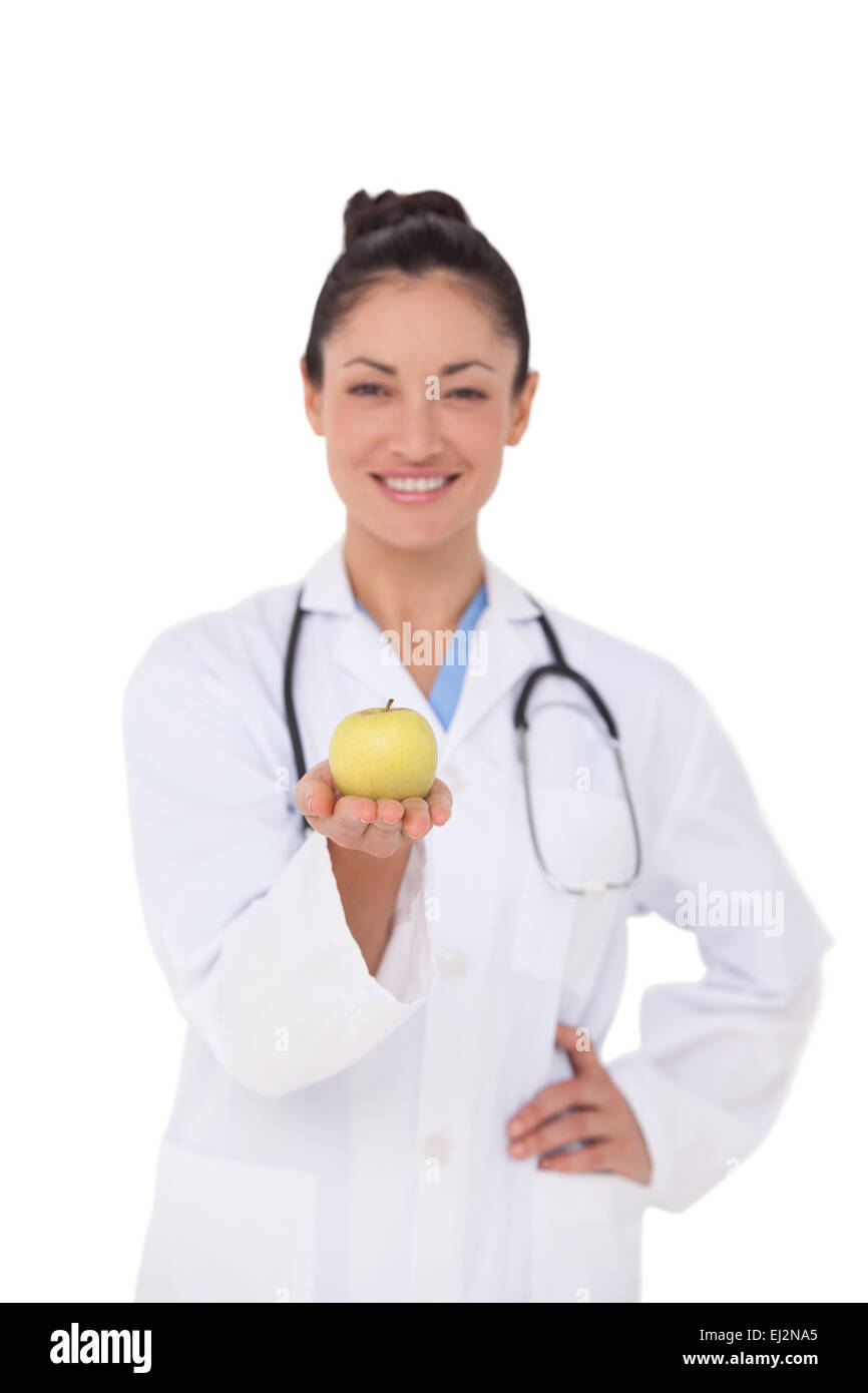 Smiling doctor offering an apple Stock Photo - Alamy