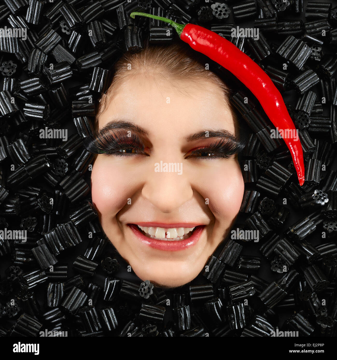 Beautiful woman face with licorice and chili frame Stock Photo - Alamy