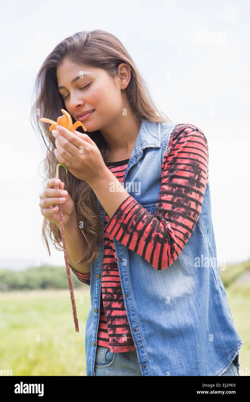 Pretty brunette smelling a flower Stock Photo - Alamy