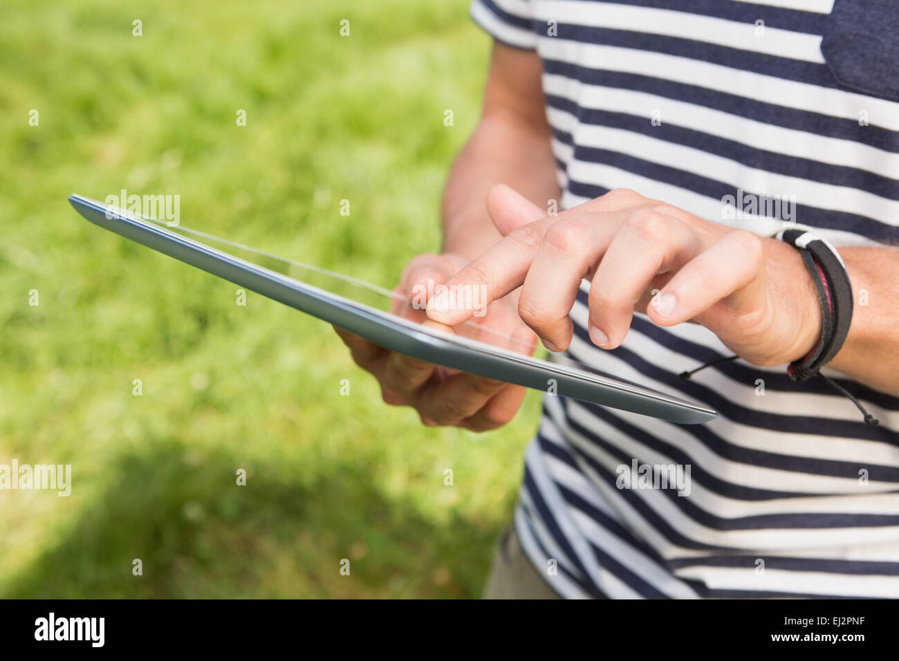 Man using a tablet in the park Stock Photo - Alamy