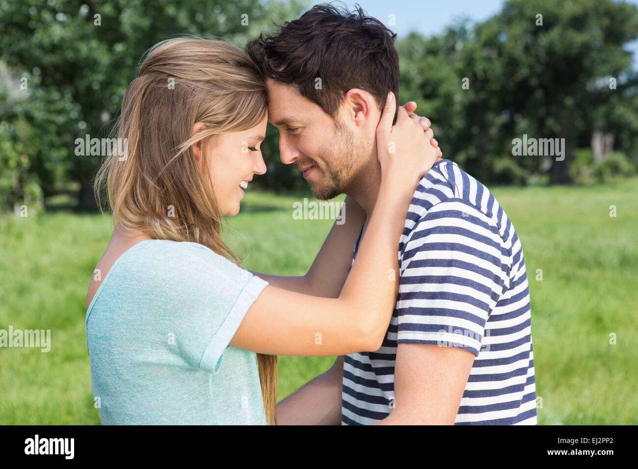 Cute couple hugging in the park Stock Photo - Alamy