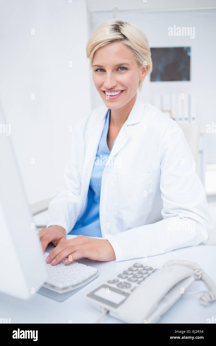 Confident female doctor using computer in clinic Stock Photo - Alamy